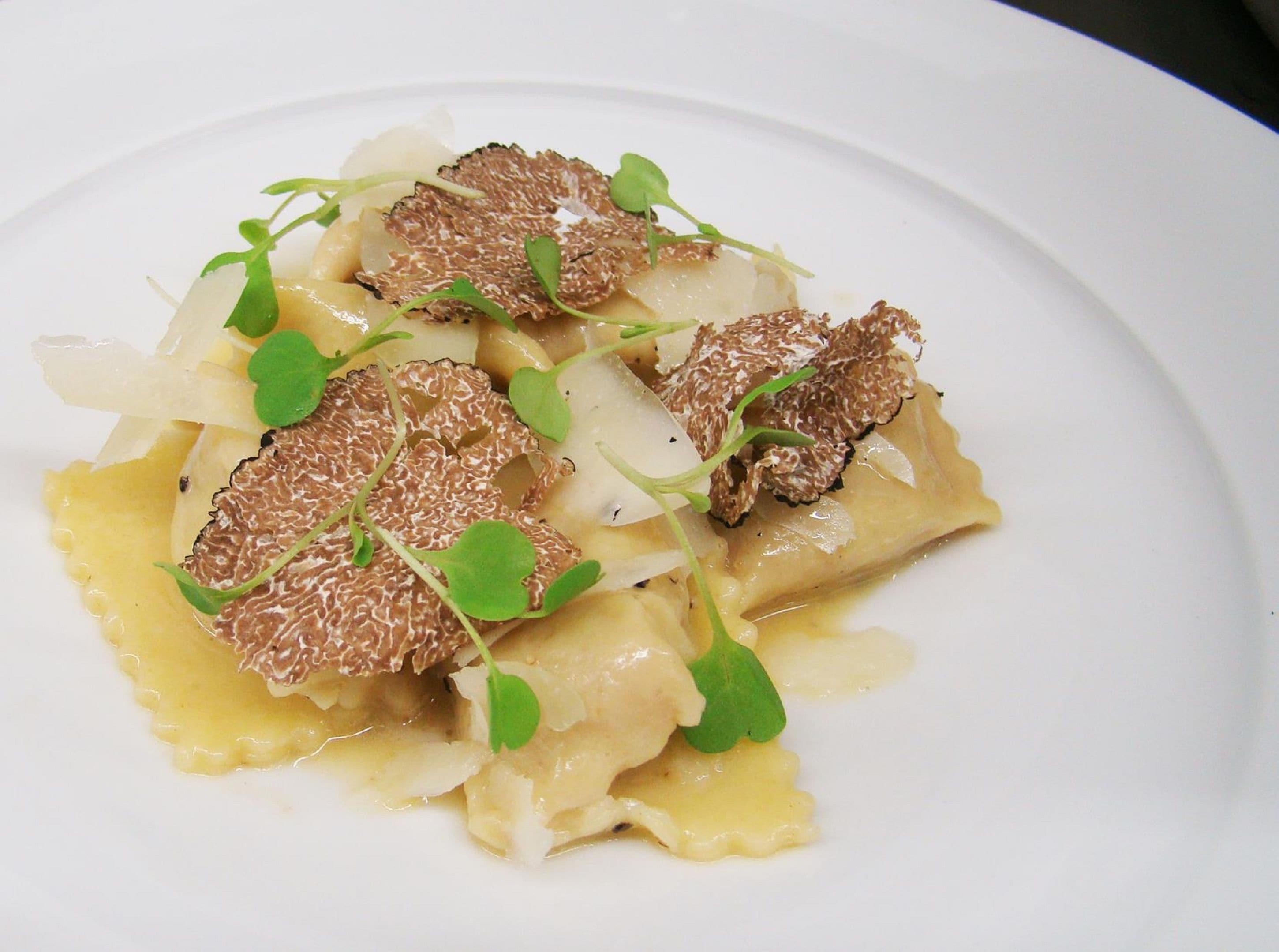 Prato de ravioli com trufas e vegetais.