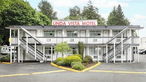 Um motel de dois andares com uma placa que diz 'LINDA VISTA MOTEL'.