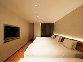Quarto de hotel com cama grande, televisão na parede e cortina.
