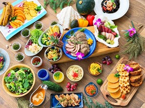 Diversos pratos e alimentos dispostos sobre uma mesa de madeira.