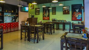 Interior de restaurante com mesas, cadeiras, balcão e decorações nas paredes.