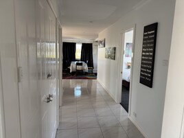 Corredor com área de jantar e uma cama ao fundo.