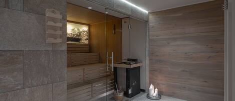 Uma sauna moderna com banco de madeira, armário de sauna e espelho.