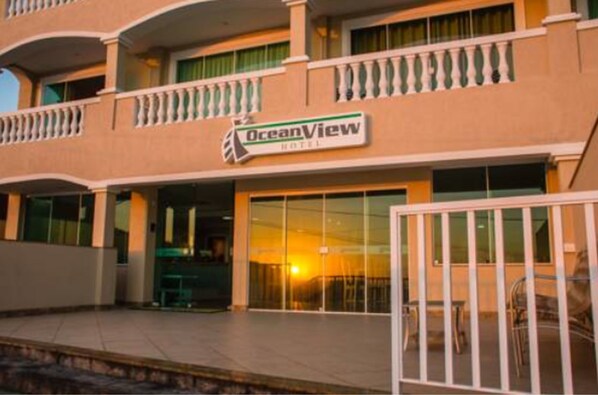 Um hotel chamado OceanView com fachada moderna, grandes janelas e área de varanda.
