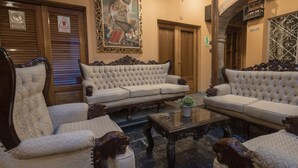 Um hall de entrada com um sofá grande e acolchoado, uma mesa de centro e um quadro emoldurado na parede.