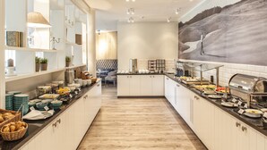 Cozinha moderna com sistema de buffet, piso de madeira e uma grande pintura na parede.