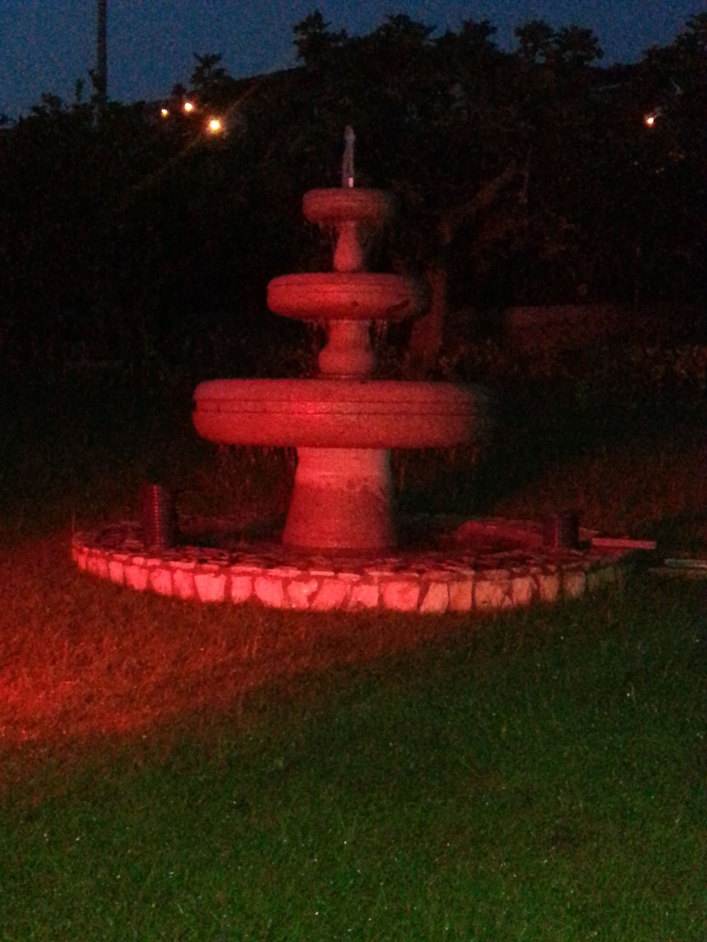 Uma fonte em vários níveis em um parque à noite.