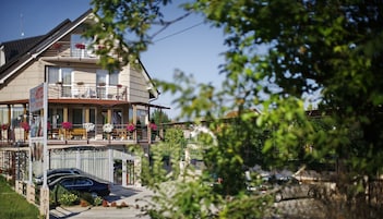 Um hotel com varanda, área de estar externa e entrada visível.