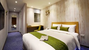 Quarto de hotel com uma cama grande, uma mesa, uma cadeira e um espelho.
