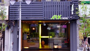Um hotel com fachada moderna, grandes janelas e entrada visível.