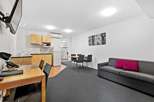Um apartamento moderno com sala de jantar, cozinha e sala de estar.