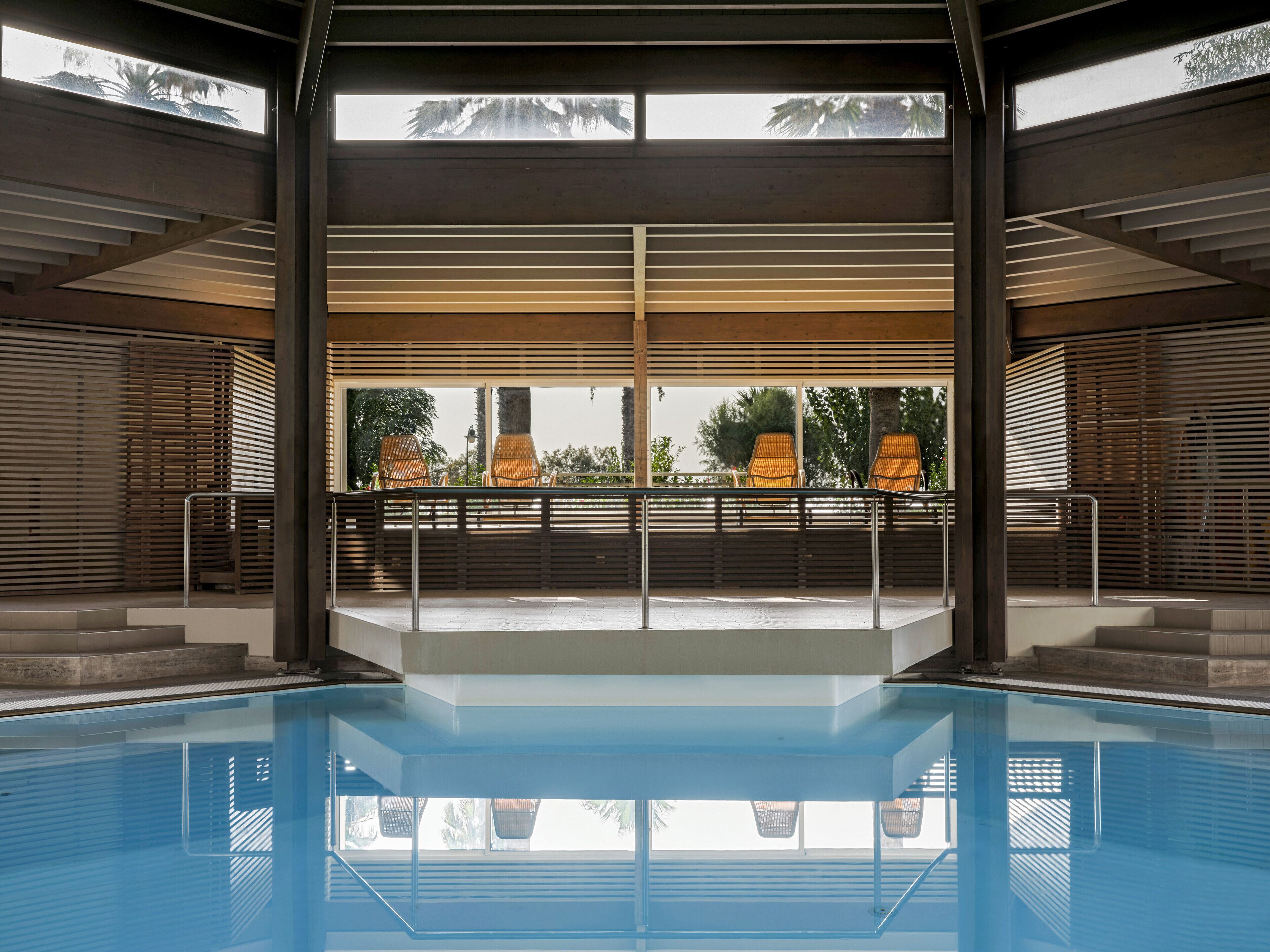 Piscina com vista para área de estar externa e espaço coberto.