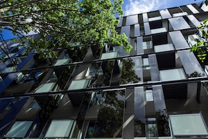 Um edifício moderno com fachada geométrica, janelas amplas e varandas.