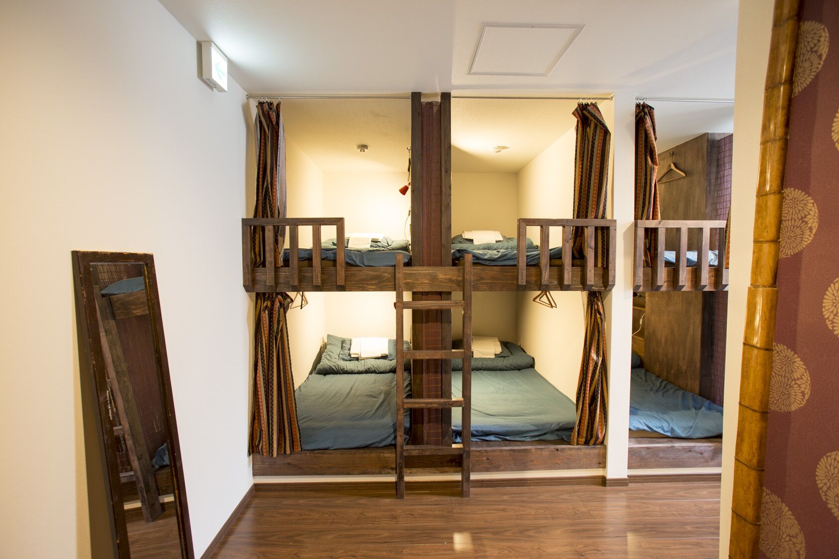 Um quarto com beliches, uma escada e uma porta.