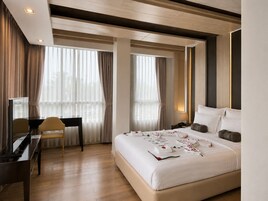 Quarto de hotel com cama, escrivaninha e cadeira.
