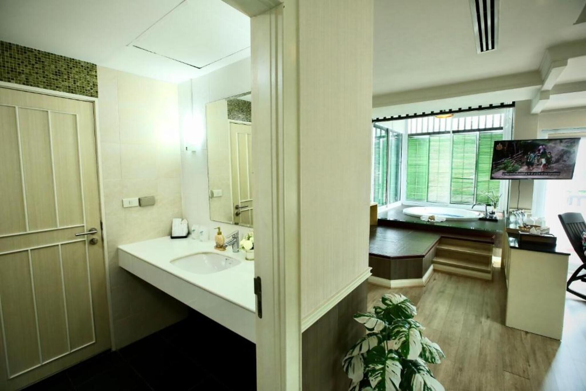 Uma casa de banho moderna com um espelho grande, uma pia e zona de duche.