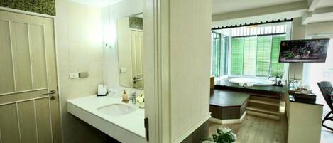 Uma casa de banho moderna com um espelho grande, uma pia e zona de duche.
