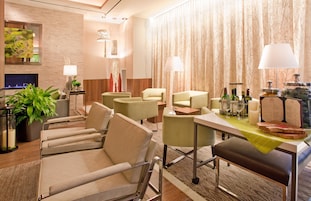 Um saguão de hotel com assentos, uma recepção e um bar.