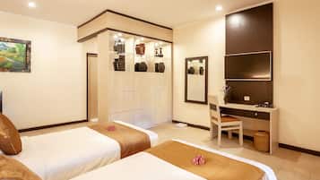Quarto de hotel com duas camas, uma escrivaninha, um espelho e uma estante com objetos decorativos.