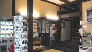 Uma livraria acolhedora com um banco de madeira, uma escadaria e uma exposição de cartões postais.