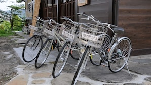Uma fileira de bicicletas com cestas presas estacionadas em frente a um prédio.