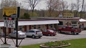 Um motel com uma placa anunciando 'TRAVELERS HAVE VEN'.