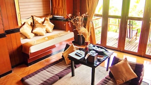 Um quarto aconchegante com sofá, uma mesinha e vista para o exterior.