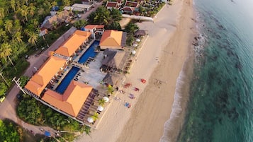 Na praia, praia de areia branca, guarda-sóis de praia, toalhas de praia
