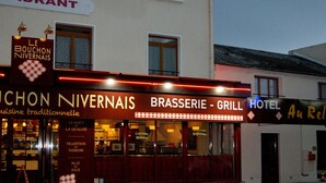 Um restaurante chamado 'Le Bouchon Nivernais' com um letreiro indicando que serve cozinha tradicional e churrasco.