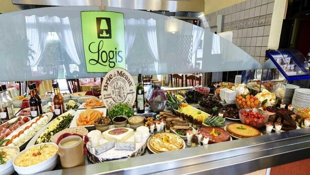 Buffet com variedade de alimentos e um letreiro com a inscrição 'Logis'.