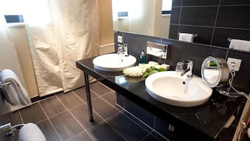 Uma casa de banho moderna com duas bacias, um espelho grande e zona de duche.