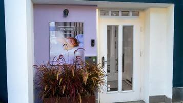 Entrada de hotel com porta, cartaz anunciando 'easy sleeping' e planta em vaso.
