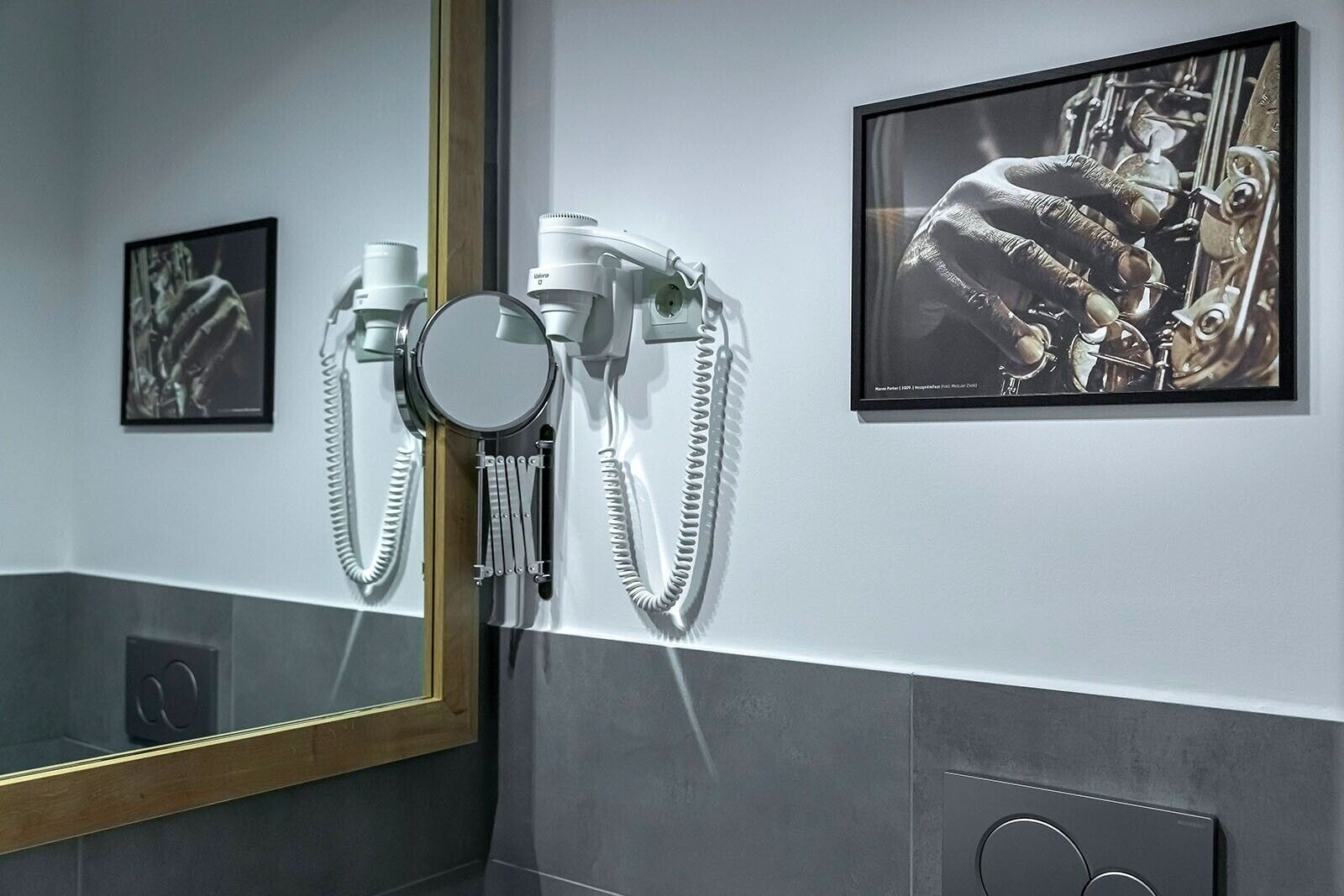 Um banheiro com espelho, porta-toalhas e um quadro na parede.