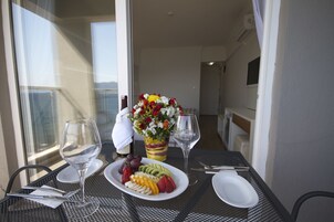 Uma mesa de jantar com um prato de frutas, um vaso de flores e taças de vinho.