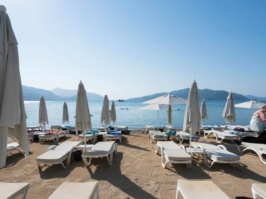 Uma praia privada, espreguiçadeiras, guarda-sóis de praia