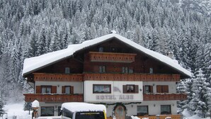 Um hotel com fachada de madeira, varandas e uma placa com a inscrição