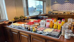 Uma mesa de buffet com diversos alimentos e bebidas.