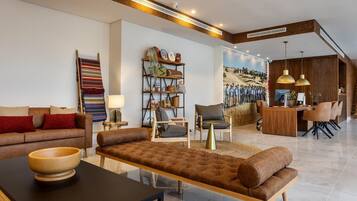 Uma sala de estar moderna com um sofá, poltronas, uma mesa de centro e uma estante.