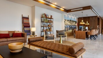 Uma sala de estar moderna com um sofá, poltronas, uma mesa de centro e uma estante.
