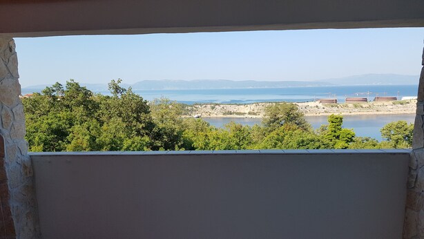 Uma varanda com vista para um lago e montanhas ao longe.
