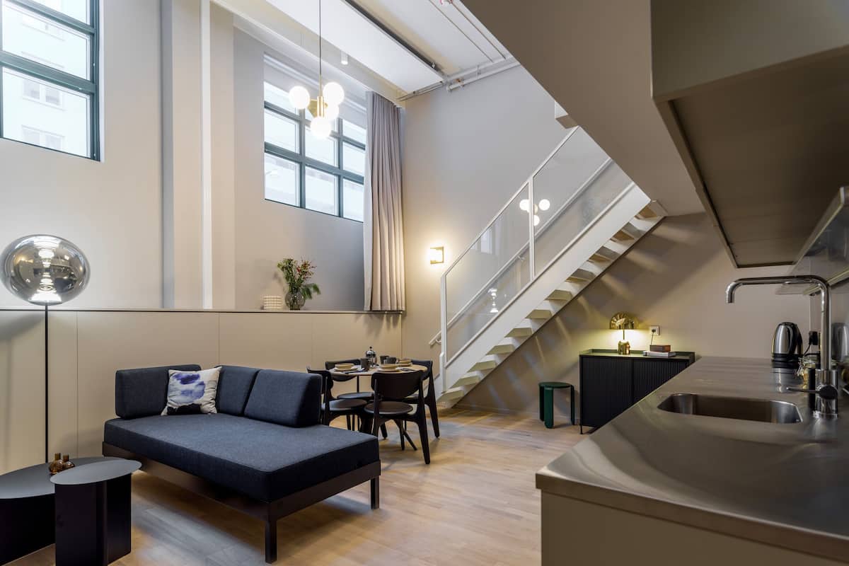 Um apartamento moderno com sala de estar, área de refeições e cozinha.