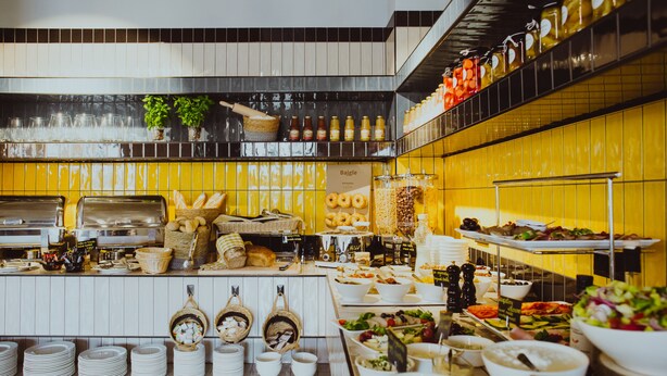 Uma área de buffet com diversos alimentos e utensílios.