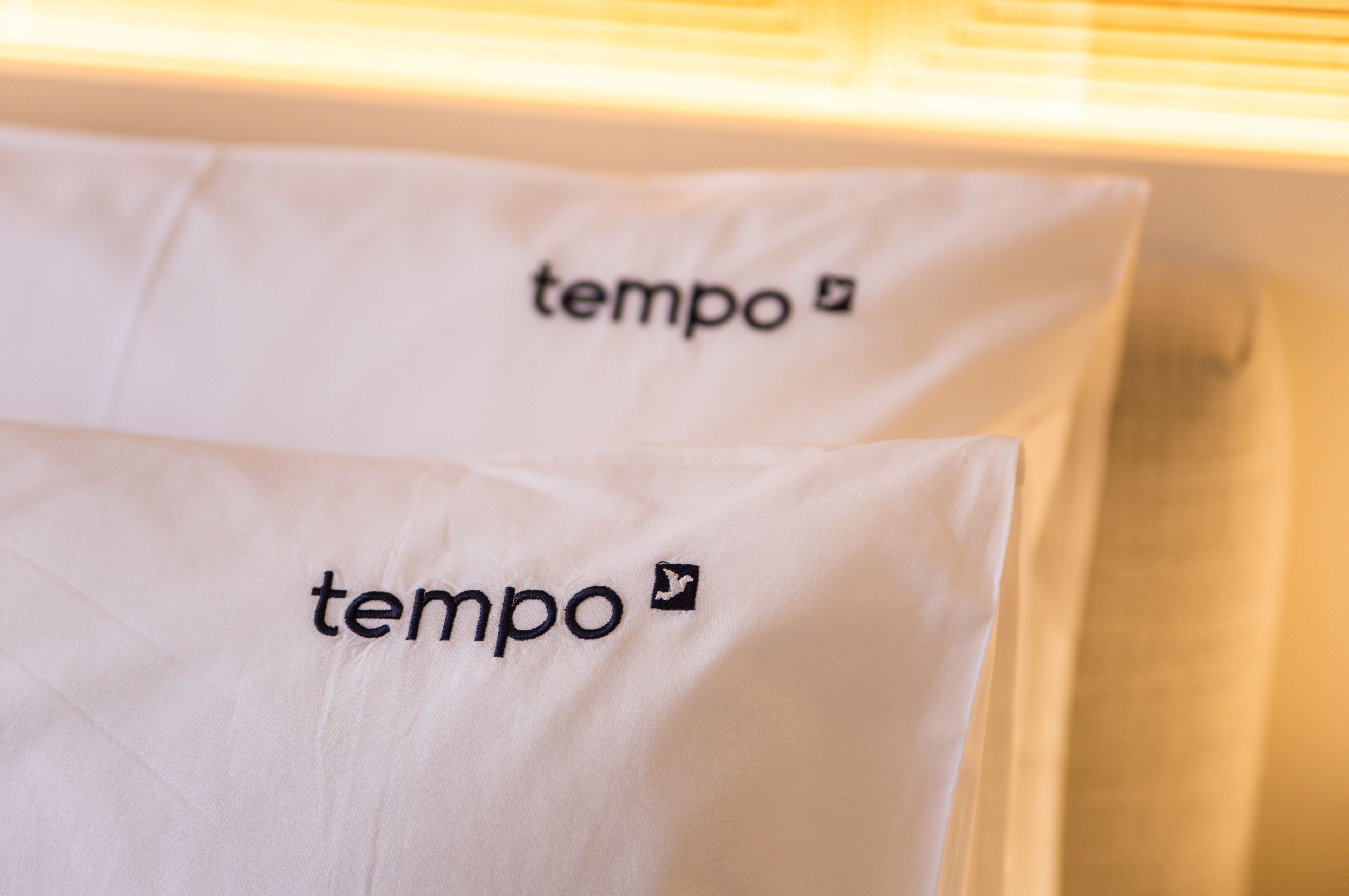 Duas almofadas brancas com a palavra 'tempo' bordada.