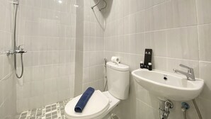 Uma casa de banho moderna com sanita, bidé e lavatório.