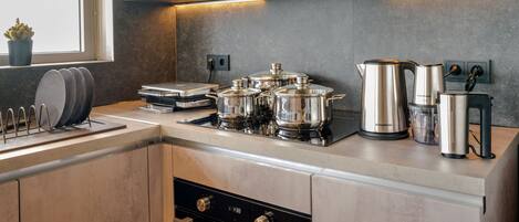 Uma cozinha moderna com eletrodomésticos de aço inoxidável, forno embutido e janela com vista.