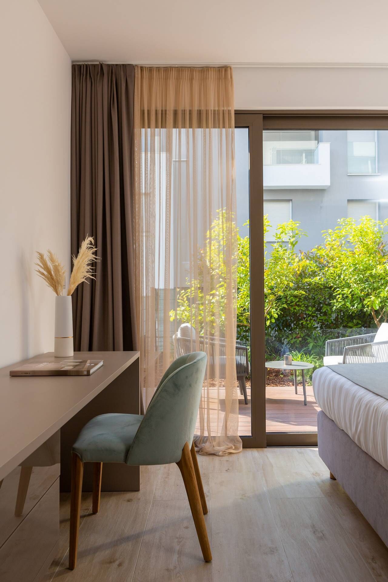 Quarto de hotel moderno com escrivaninha, cadeira e cama.