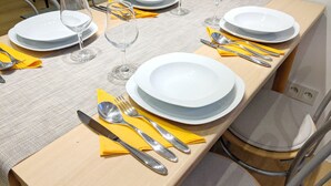 Uma mesa posta com pratos brancos, talheres e guardanapos amarelos.