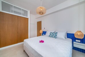 Quarto com cama, guarda-roupa de madeira e parede com azulejos azuis.