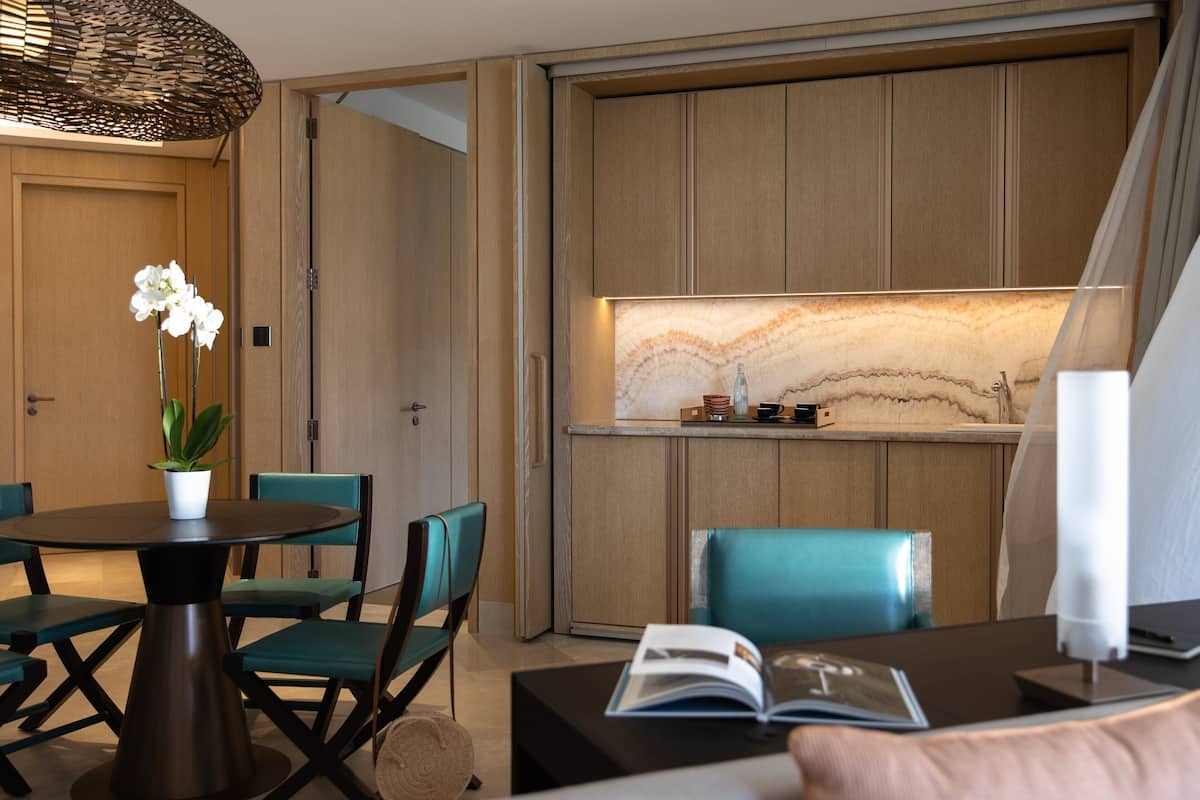 Um interior moderno com área de refeições, cozinha com painel de mármore e vista da cidade.