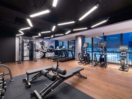 Uma academia com esteiras, elípticos e equipamentos de musculação.
